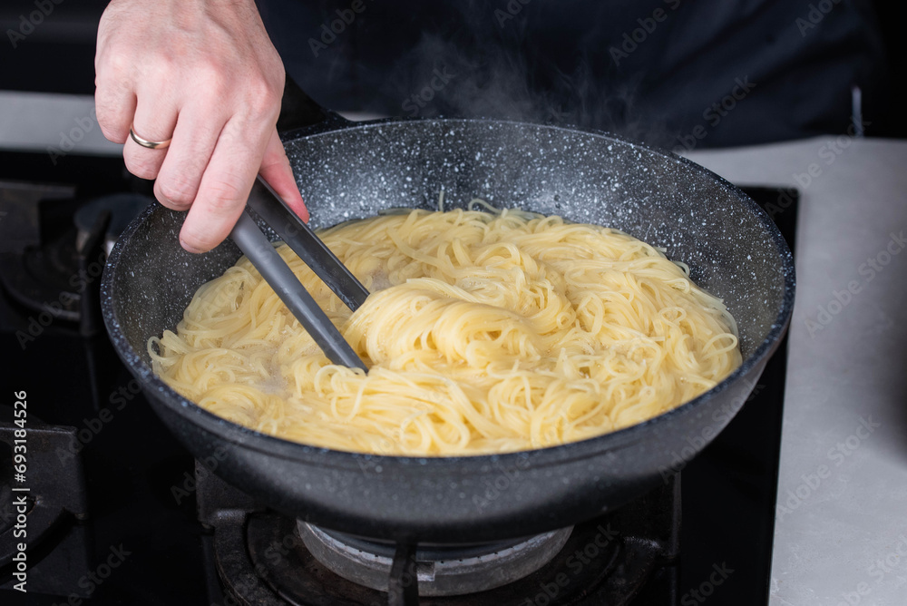 Professional chef cooks making Italian Capellini spaghetti pasta at ...