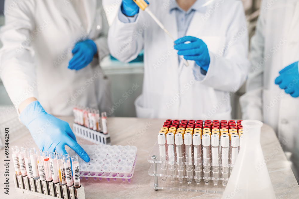 A group of people in medical gowns and disposable gloves conducts ...
