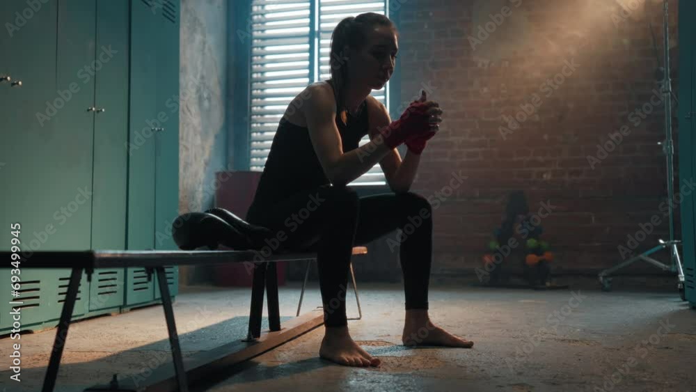 Focused young woman fighter boxer wraps hands wrists with boxing ...