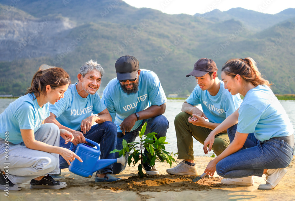 group of diverse people in unity volunteer T-shirt are planting trees ...