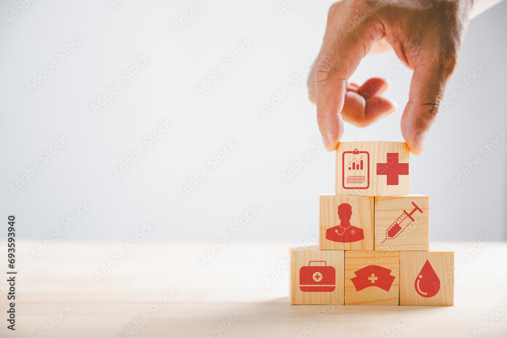 Conceptual portrayal, Hand clutches wooden block with healthcare and ...