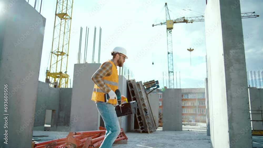 Happy construction worker at construction site dancing with boxtool and ...