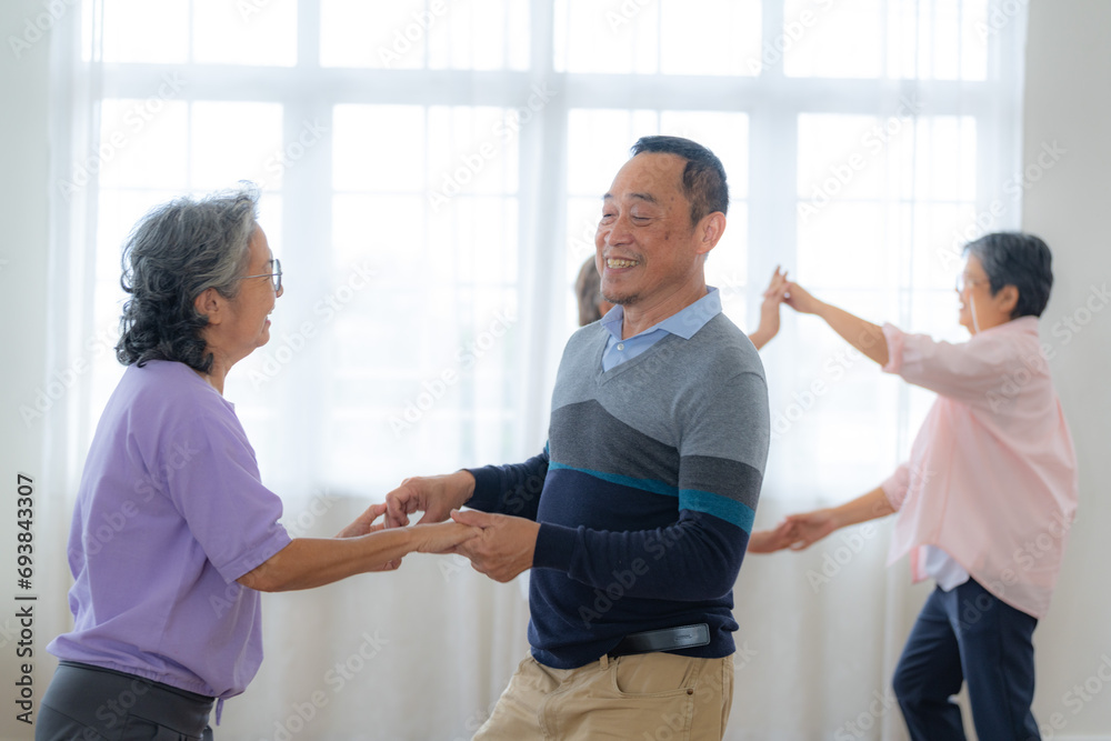 Asian Older male and females people dance with their partners on a ...