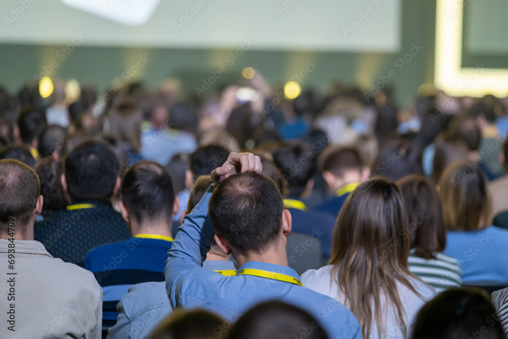 Back view of businessman sitting with head on head while attending ...