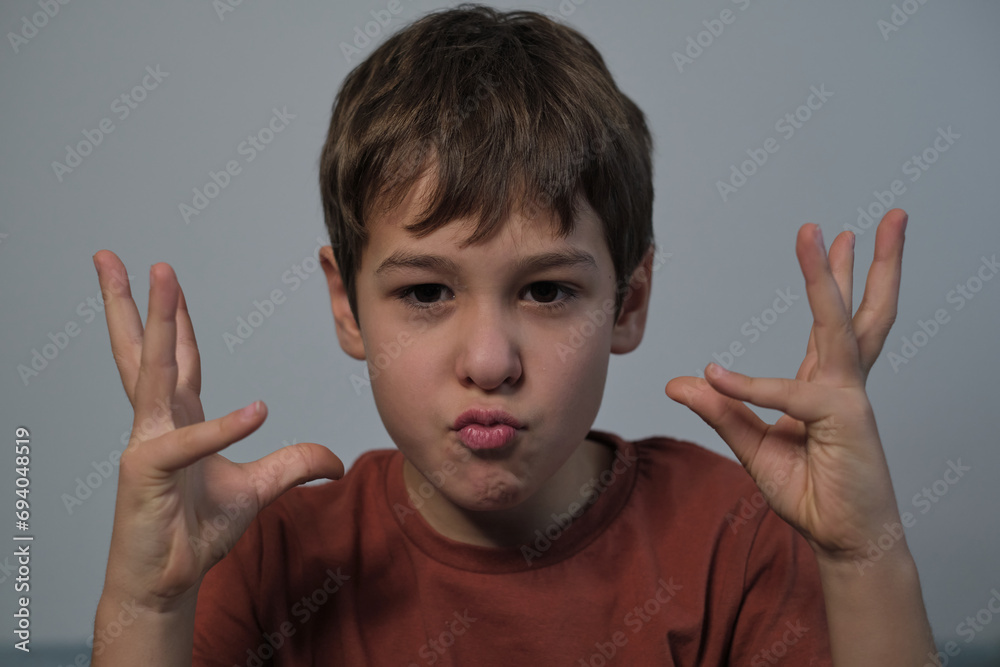 Boy mimicking an animal with hands, puckered lips for effect. Captures ...