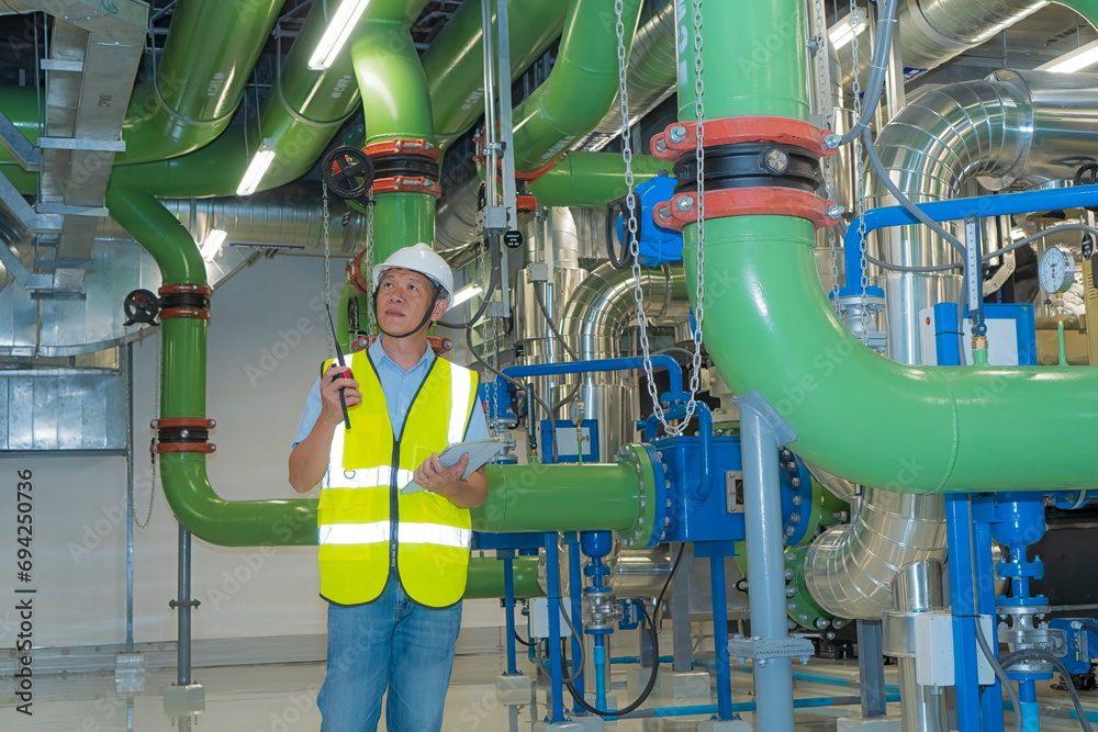 engineer work on chiller plant. worker checking on chiller water plant ...