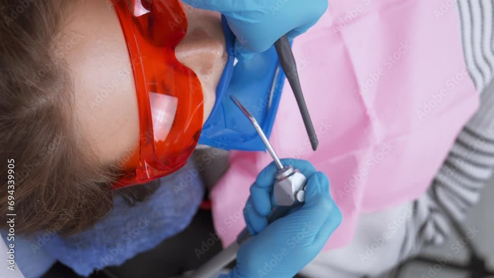 Dentist's hands in gloves with dental punch and cofferdam scarf ...