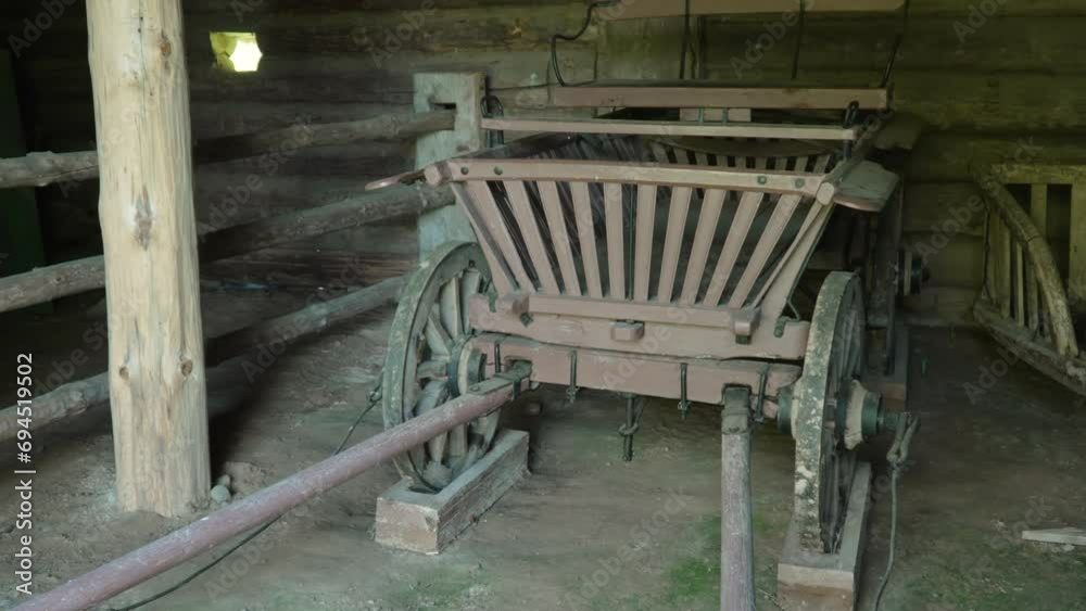 Wooden cart with seat on old handmade wheels stands in barn. Simple ...