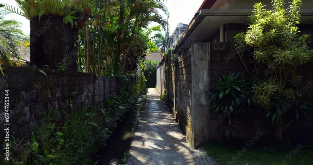 Closed wall or fence on left and right, concrete walkway with a water ...