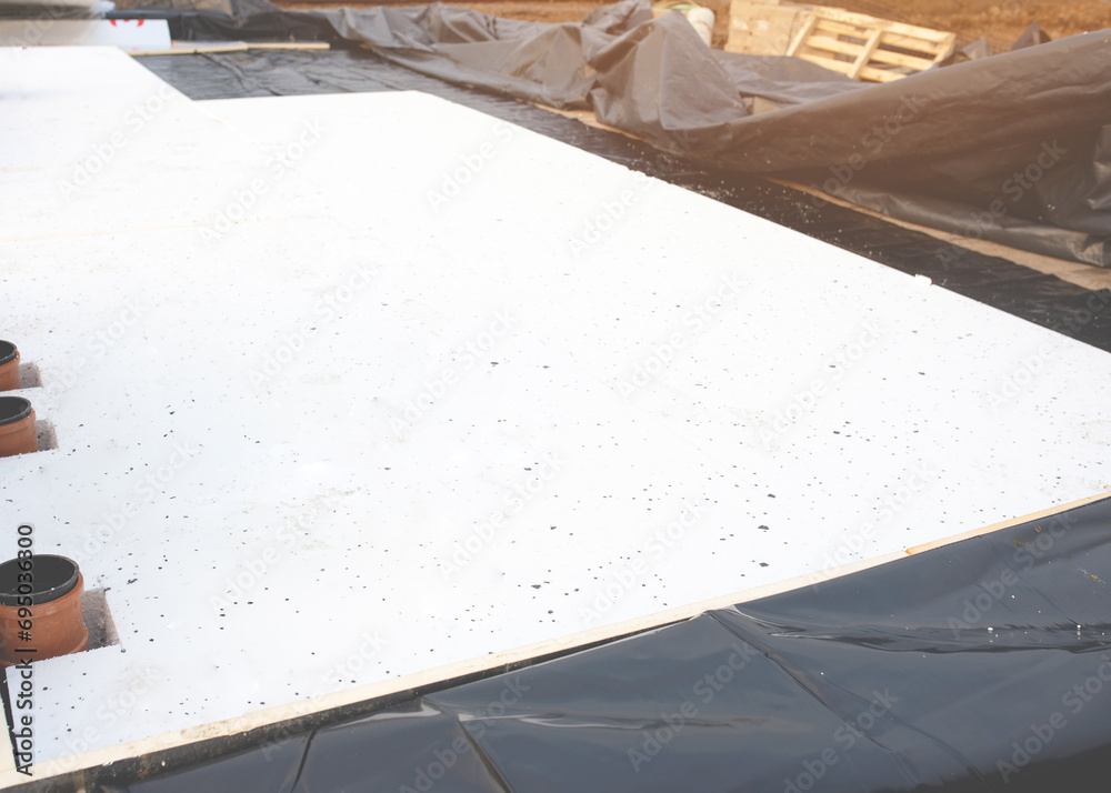 Waterproof membrane and underfloor insulation is being placed by ...