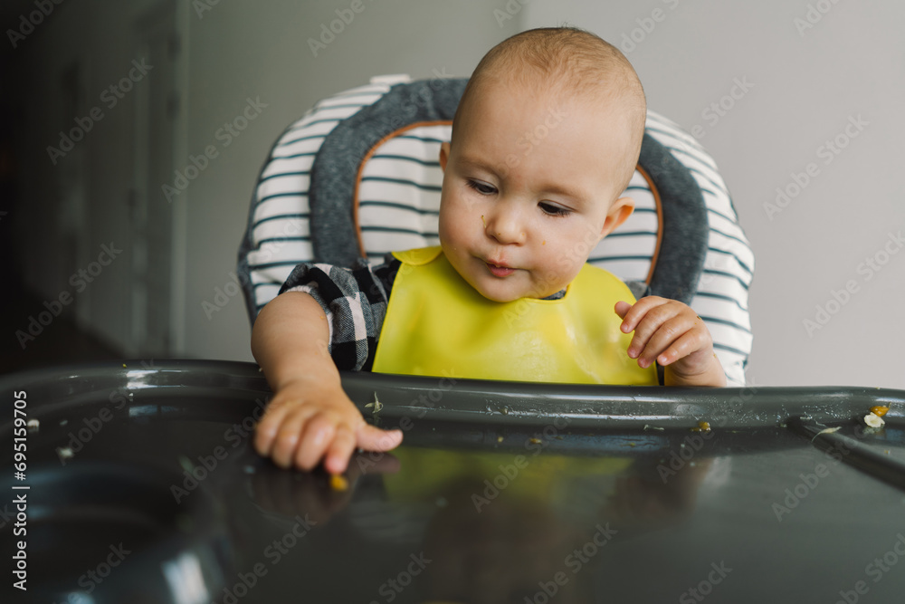 Little child with solid nutrition. Baby girl eating finger food and mix ...