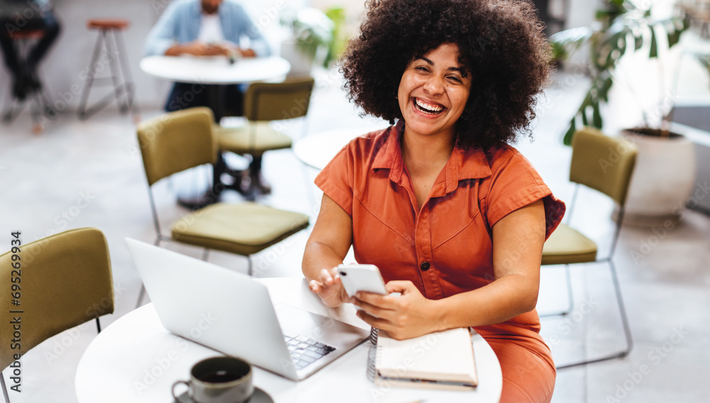 Happy remote worker using smartphone and laptop in cafe Stock Photo ...