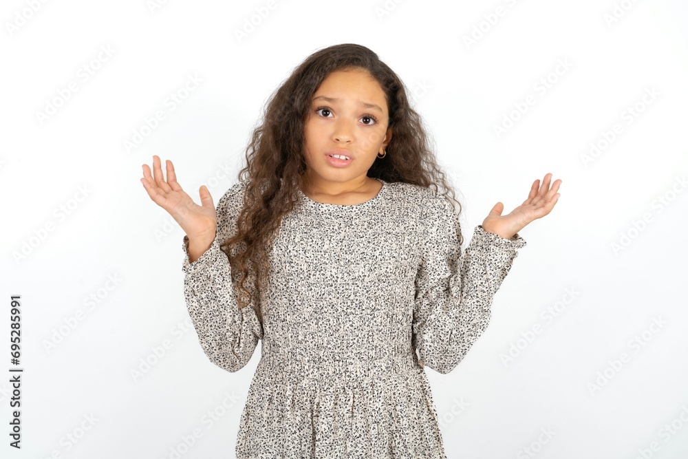 Clueless Beautiful teen girl wearing flowered dress shrugs shoulders ...