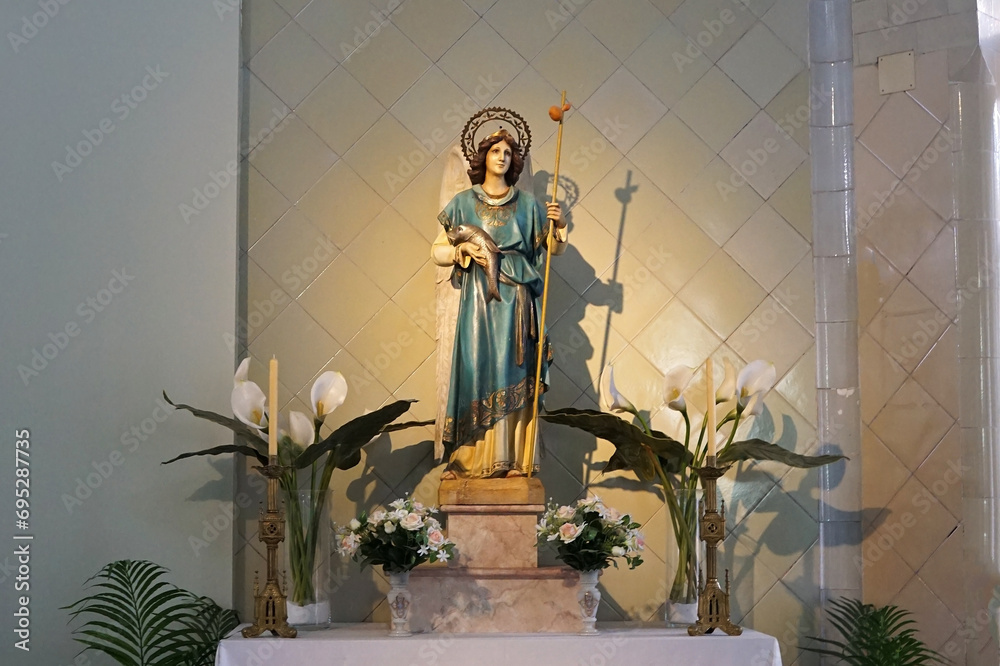 Holy statue shrine figure of St. Raphael, the Archangel holding staff ...