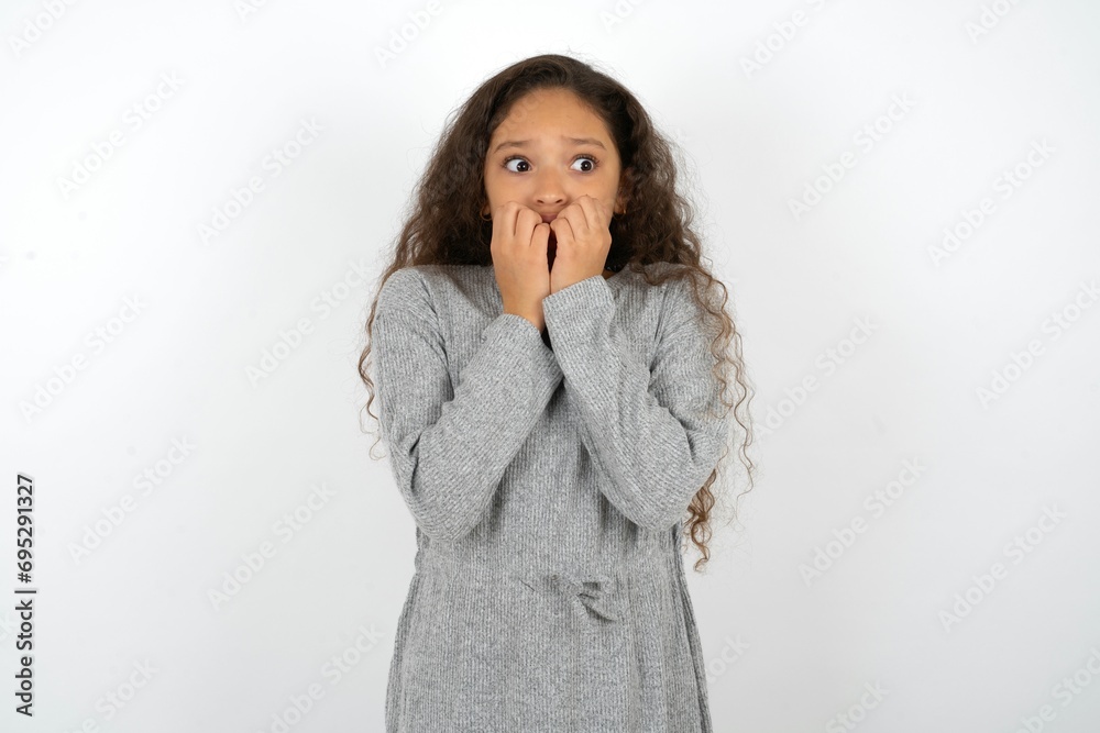 Fearful Beautiful teen girl wearing grey dress over white background ...