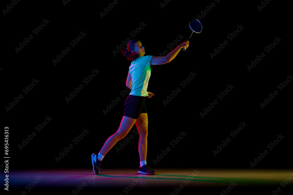 Full length portrait of skilled female badminton player in motion ...