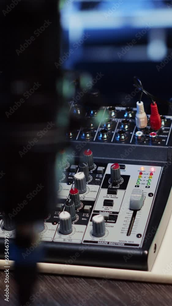Vertical video Panning shot of professional analog mixer and microphone ...