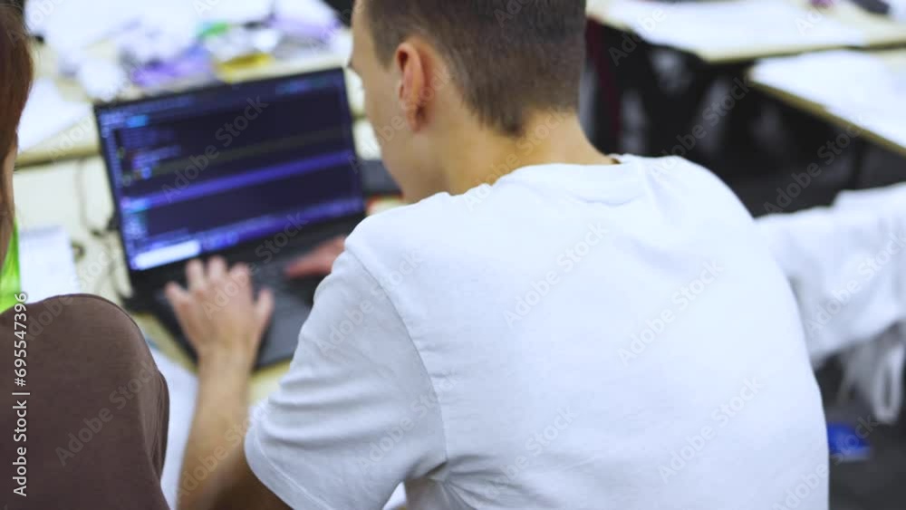 Software developer students in auditorium hall working on computer and laptop, programming ...