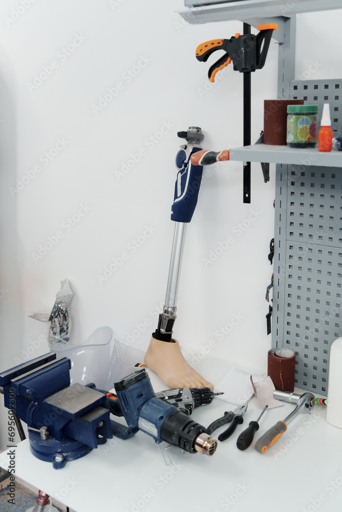 Inside a prosthetic workshop, an artificial limb stands among ...