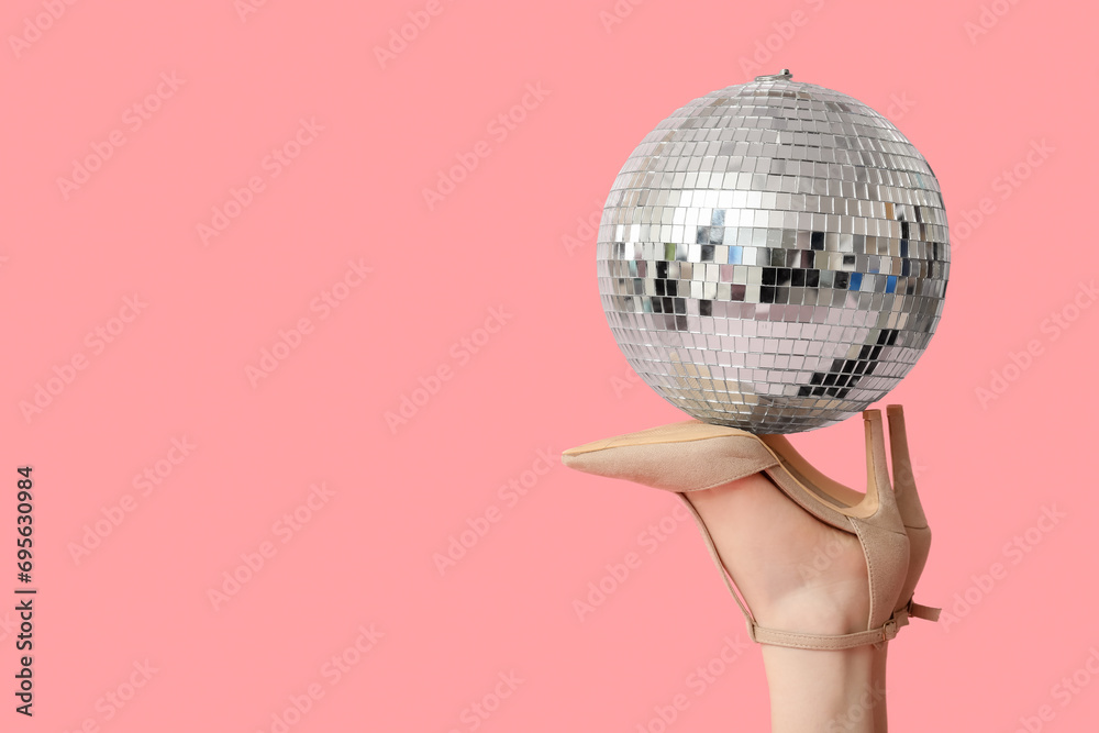 Female legs in trendy high heels with disco ball on pink background ...