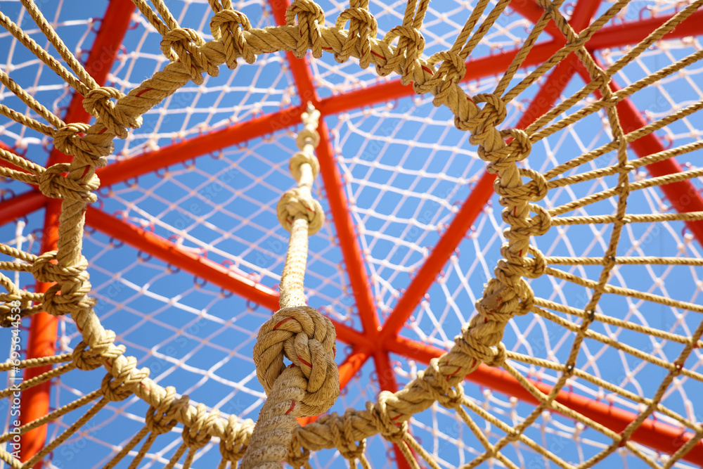 Twisted rope on children's play. Closeup of a knot of cream colored ...