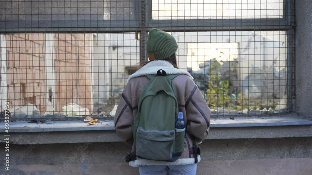 Young sad homeless woman depressed and abandoned standing on the street ...