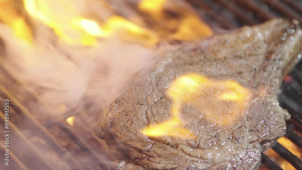 Roast beef with fire flames. Beef steak on grill with flames. Rib-eye ...