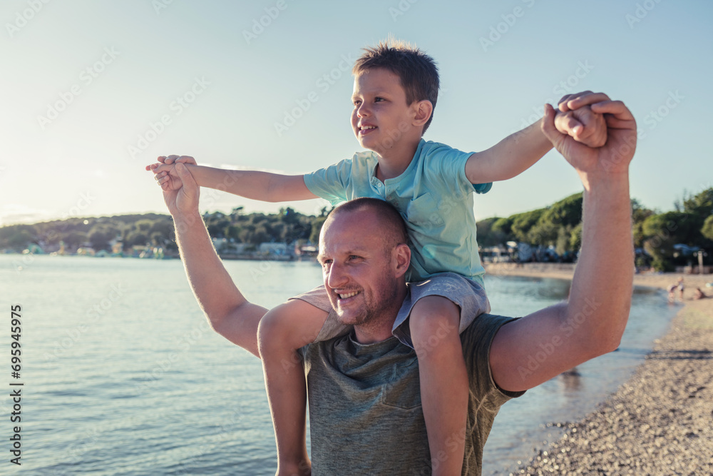 Cute little Caucasian boy from behind cheering with arms outstretched ...