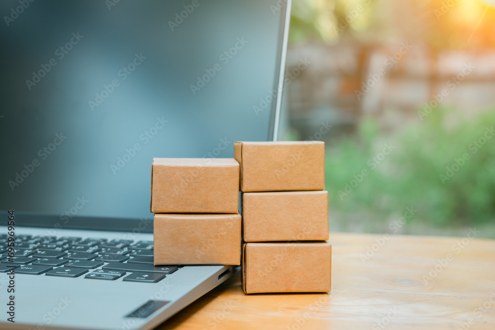 Paper cartons or parcel with shopping cart logo on laptop keyboard for ...