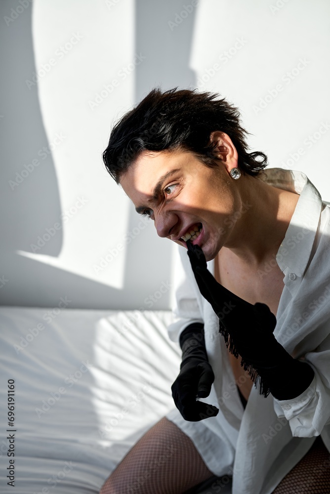 angry brunette actor in white shirt biting his gloves, taking off them ...