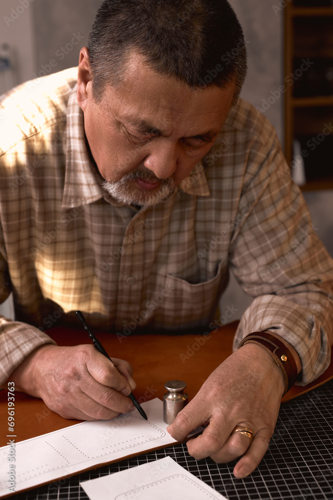 bearded man focus on working with stitching awl at workplace, close up ...