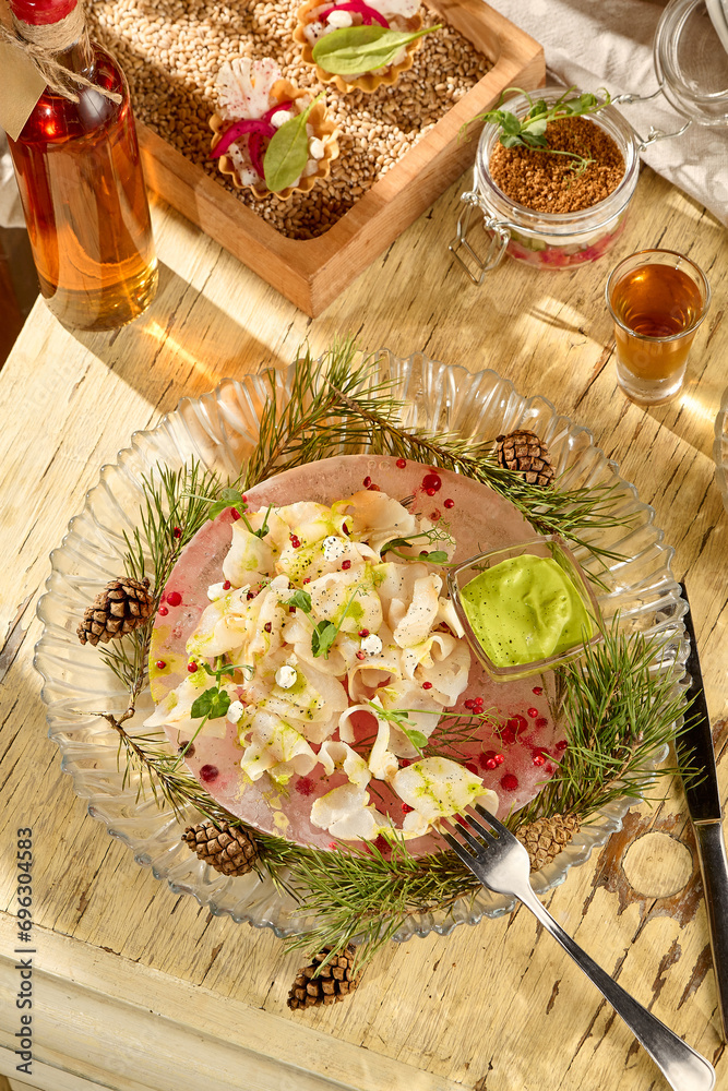 Overhead view of stroganina, thinly sliced frozen fish, with pine ...