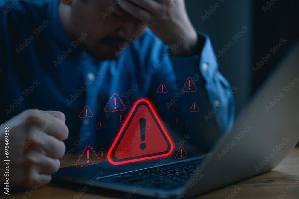 User is using computer with triangle caution warning sign for notification error and maintenance ...