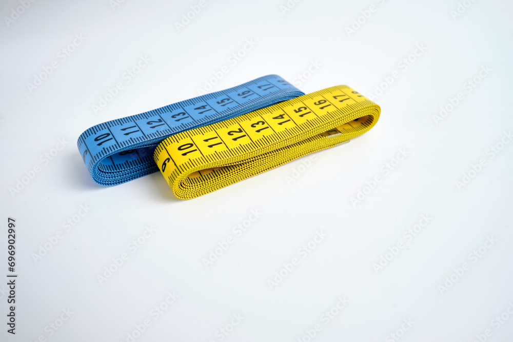 Multi-colored measuring tapes on a light background. Tool for measuring ...