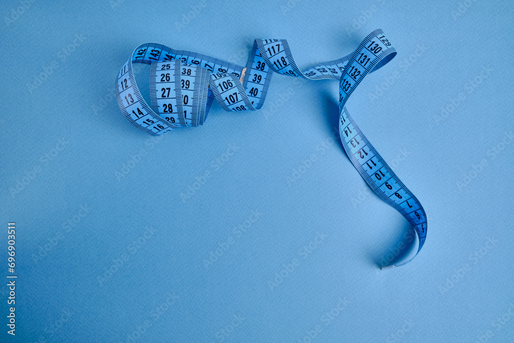 Blue measuring tape on a blue background. Tool for measuring length and ...