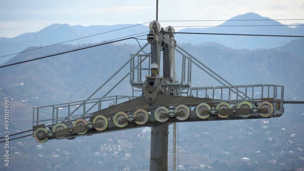 Support of ski lift with rotating rollers. Cable car passes by the ...