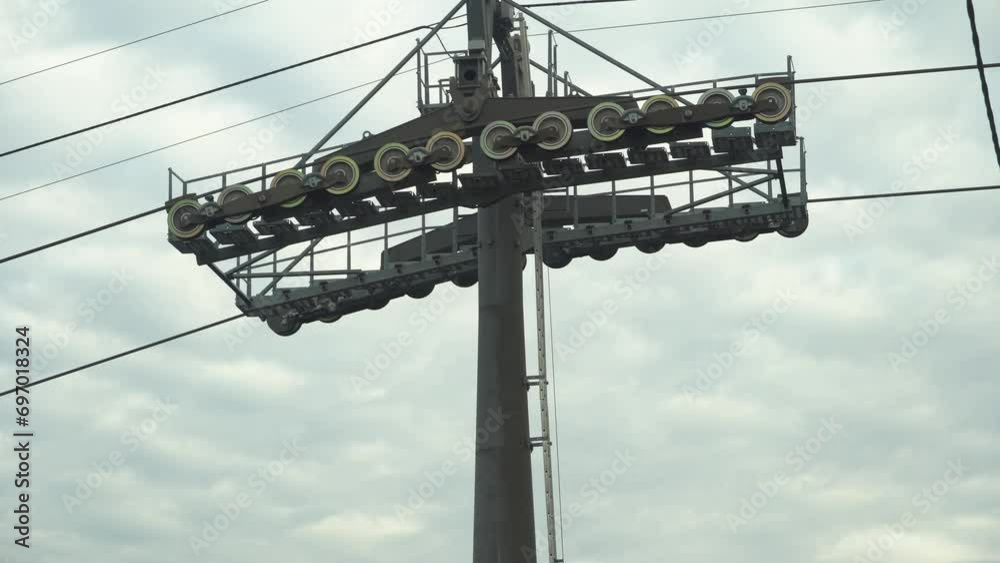 Support of ski lift with rotating rollers. Cable car passes by the ...