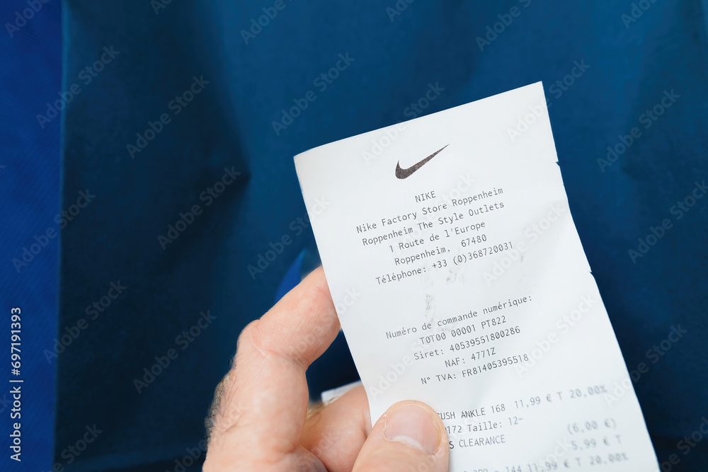 Paris, France - Nov 3, 2023: Male hand presenting a receipt from Nike ...