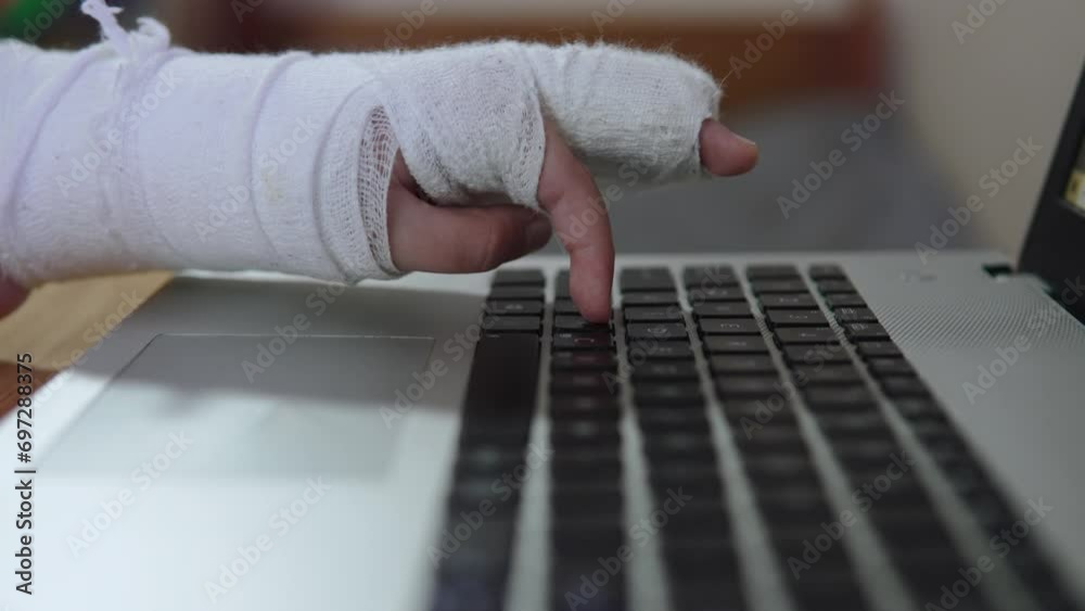 Unrecognizable child in cast types with one index finger on laptop ...