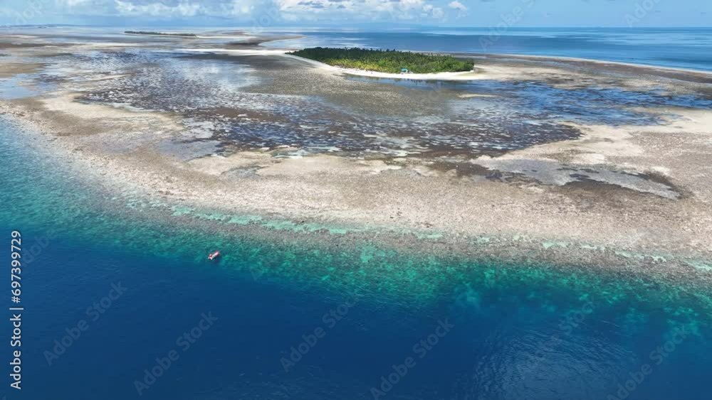 Clear water covers a beautiful reef surrounding the remote island of ...