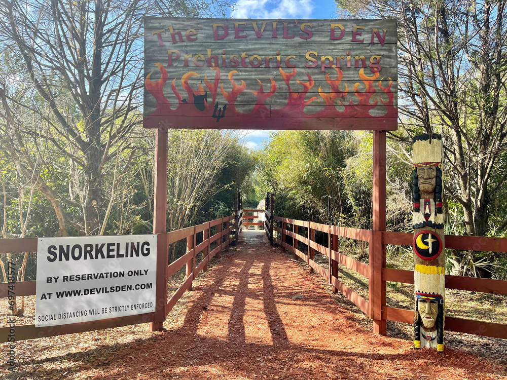 Welcome sign with devil and pitchfork at entrance to the sinkhole at ...