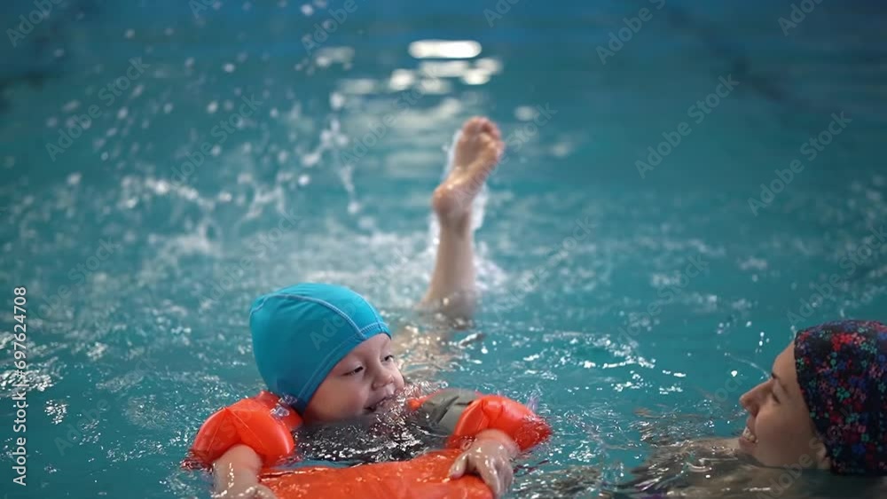 family in the pool. mother and daughter. mother teaches daughter to ...