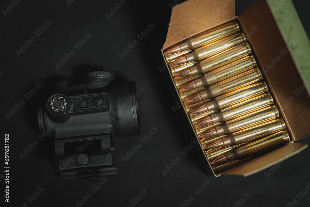 Red dot sight for firearms and 5.56x45mm ammo box, close-up photography ...