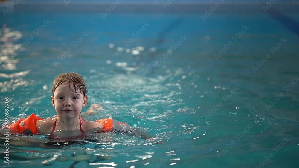 family in the pool. child swims in the pool. dad teaches daughter to ...