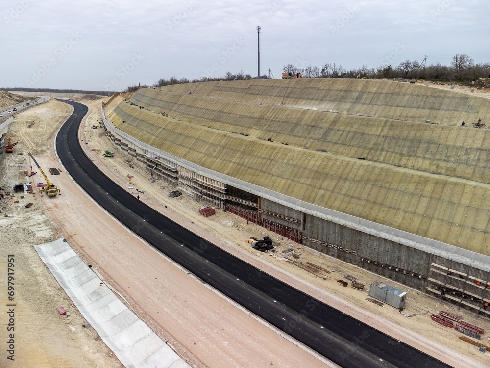 Mountain road constraction. Workers reinforce the slope over the new ...