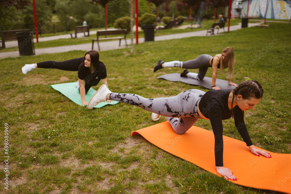 Female trainer with braids shows fitness exercise to ladies on mat on ...