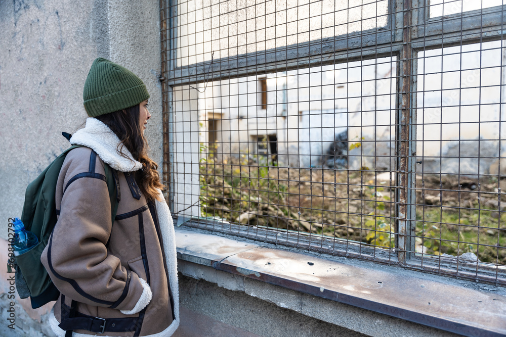 Young sad homeless woman depressed and abandoned standing on the street ...