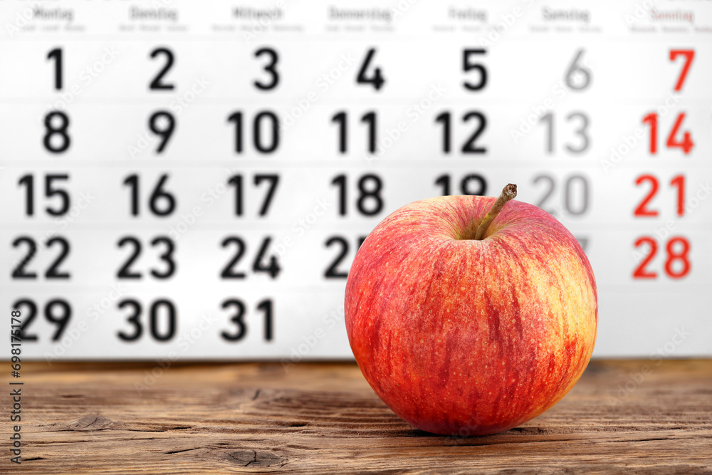One fresh red apple in front of a monthly calendar, medical nutrition ...