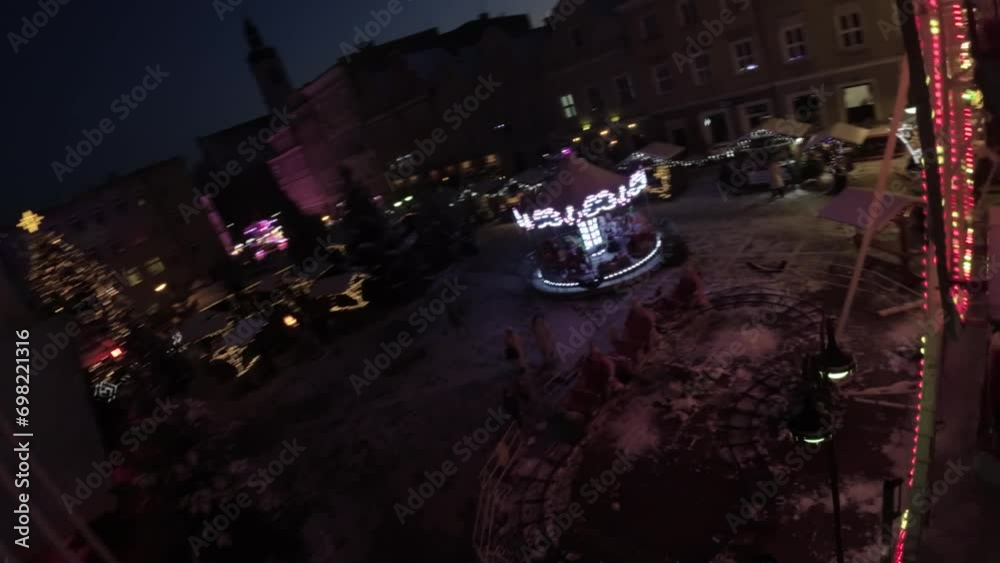 A beautiful carousel with bright lights is the centerpiece of a snowy ...