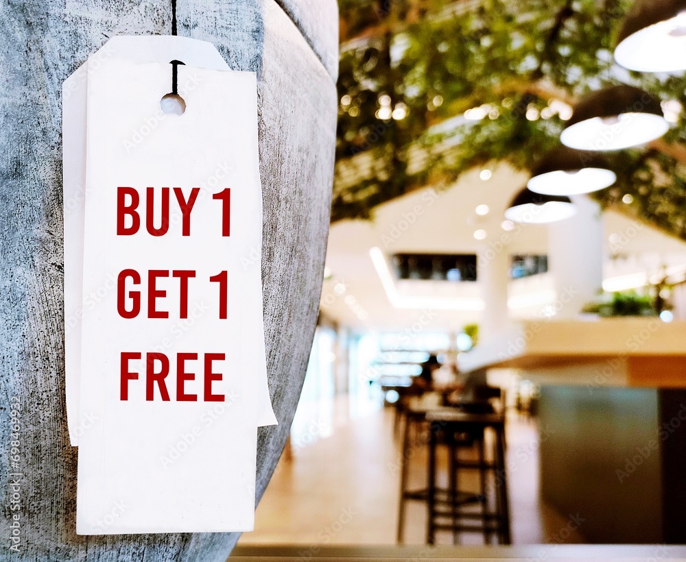 Price tag hanging on product item in store with text written BUY 1 GET ...